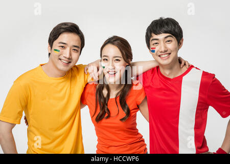 Three young smiling people cheering Stock Photo - Alamy