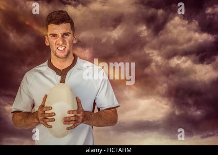 Portrait of an angry rugby player holding ball Stock Photo - Alamy
