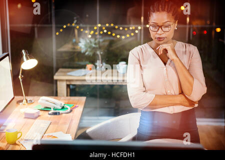 businesswoman looking at desktop computer while standing at desk Stock ...