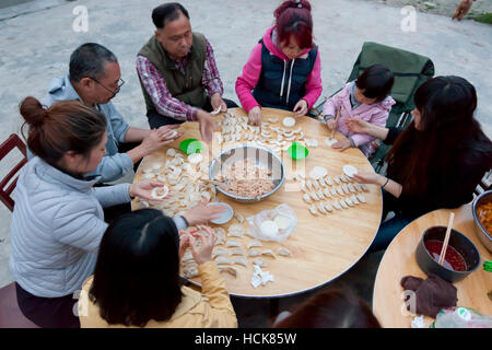 Family Making Dumplings In Courtyard Stock Photo - Alamy