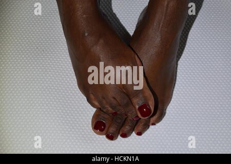 Beautiful african feet pedicured with red nail polish Stock Photo - Alamy