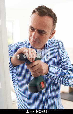 A man using a power tool electric sander to craft wood in the carpentry ...