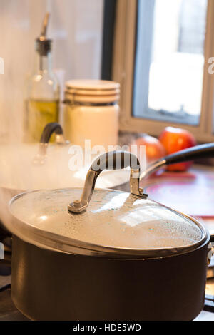 steam over cooking pot on a red background Stock Photo - Alamy