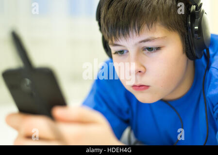 Teen boy with headphones using tablet on isolated background Stock ...