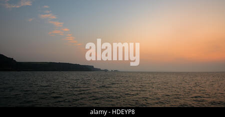 Calming sunrise over Monkstone Point looking across Carmarthen Bay ...