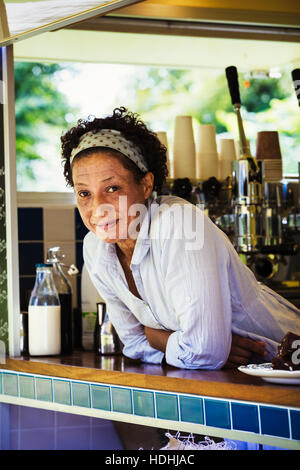 Mixed race businesswoman leaning over conference table Stock Photo - Alamy