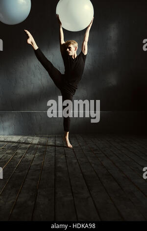 Young male professional dancer dancing in studio isolated on gray ...