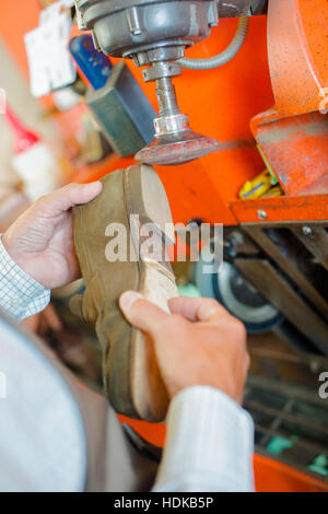 Cobbler shaping heel of shoe Stock Photo - Alamy
