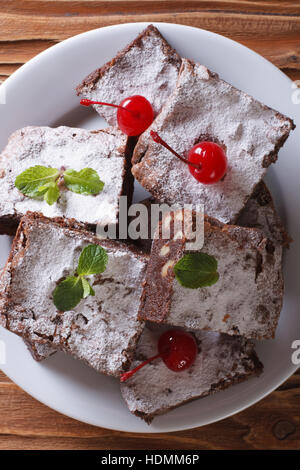 Chocolate dessert with cherries and mint on a plate on a burgundy ...