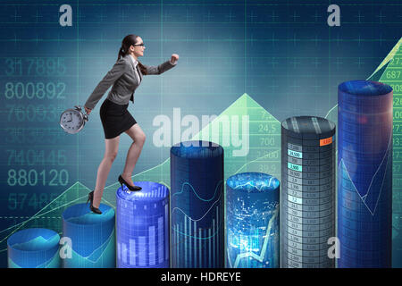 Businesswoman rushing with clock on bar charts Stock Photo - Alamy