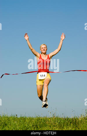 Woman jubilantly crossing the finish line, symbolic image for career ...