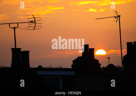 Silhouette of chimneys during winter golden glow sunset over north ...
