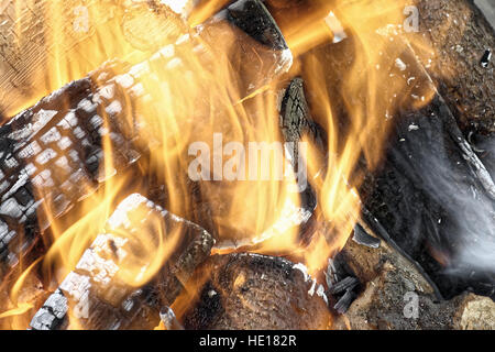 old burnt firewood logs in firepit outside in the northern summer macro ...