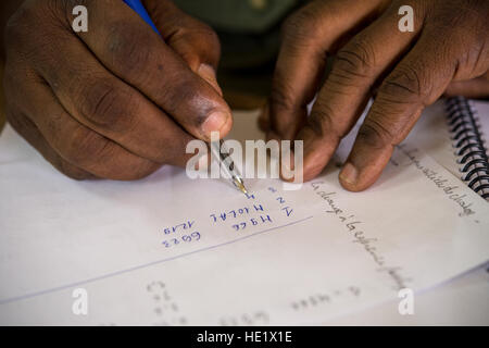 A Gabonese Air Force member works a load plan calculation during a ...