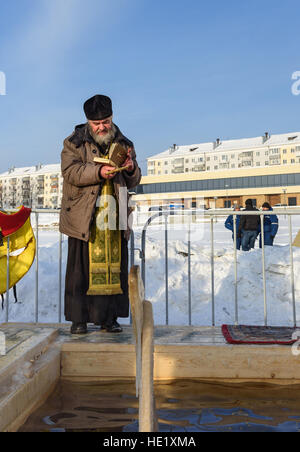 Priest consecrates the ice hole on Epiphany day. Traditional ice ...