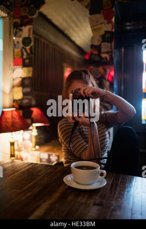 Woman clicking a picture of coffee in the bar Stock Photo - Alamy