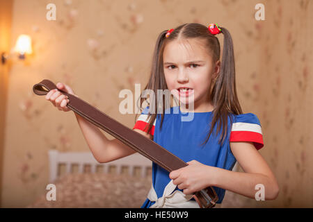 Angry girl with belt in hand. evil girl holds a strap of python, firy ...