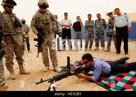 An Iraqi police officer demonstrates proper clearing procedures on an ...