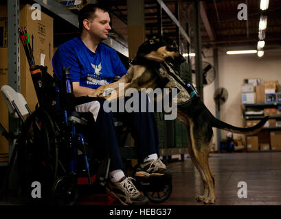 Brian Schaaf, a Warrior Games athlete, pets a service dog during a ...