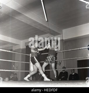 1960s, historical, two male boxers in a rig boxing at a youth club ...