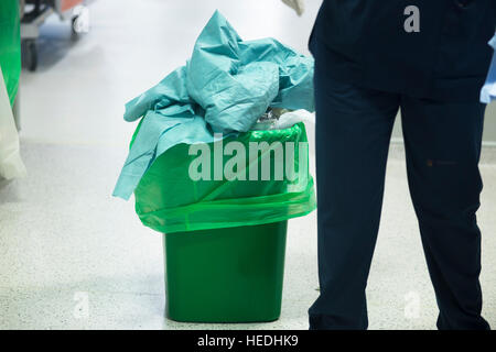 Operating theater surgery trash bin and nurse with green plastic bag ...