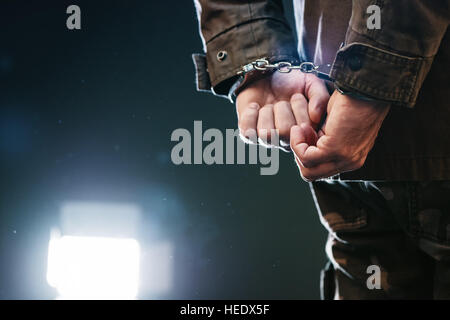 Handcuffed soldier, arrested male army officer in dark prison cell ...
