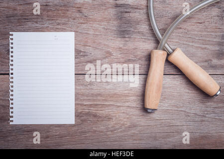 Close up skipping rope and lined paper on wooden table top view Stock ...
