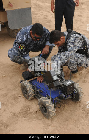 Iraqi police counter explosive team members replace the battery on an ...
