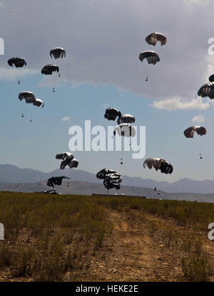 An aircraft drops fuel cans tied to parachutes during a supply air drop ...