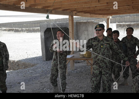 Afghan National Army soldiers use a pulley system to remove a simulated ...