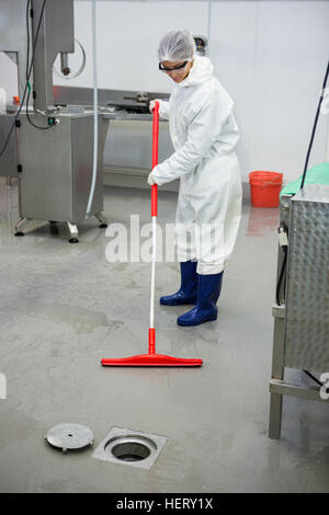 Female butcher cleaning the floor at meat factory Stock Photo ...