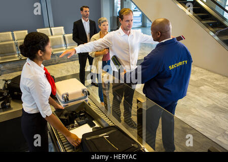 Security guard frisking a passenger at airport terminal Stock Photo - Alamy