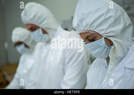 Close-up of butchers wearing mask at meat factory Stock Photo - Alamy