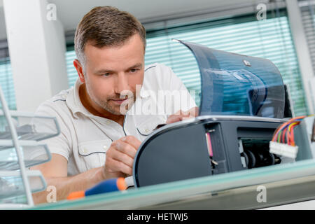 middle aged man fixing a printer Stock Photo - Alamy