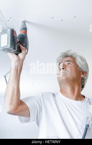 Mason drilling into a ceiling Stock Photo - Alamy