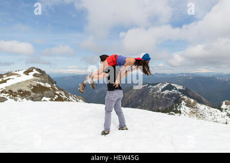 Young man carrying young woman over his shoulder in river by Tibumana ...