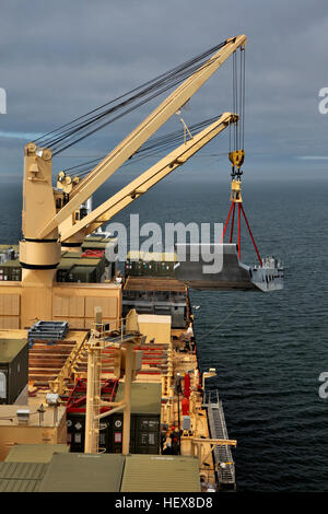 A crane offloads a beach landing module off the USNS Sgt. William ...