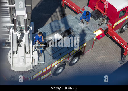 Mechanics maintaining fire engine Stock Photo - Alamy