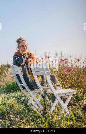 Young woman relaxing in cottage garden Stock Photo - Alamy