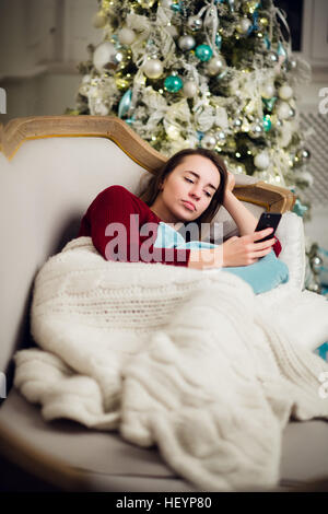 Young woman checking messages on the cell phone, inside a coworkin ...
