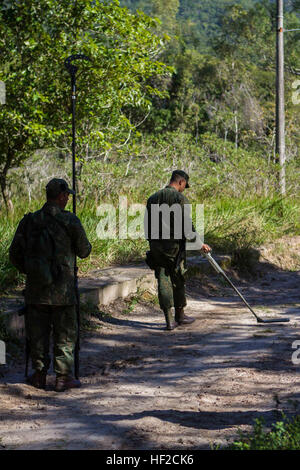 A Brazilian special forces Marine utilizes a holly stick to inspect the ...