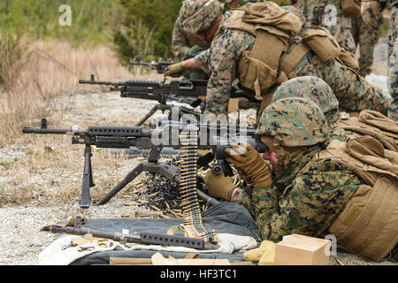 A Marine prepares to fire his M240 machine gun while riding in a ...