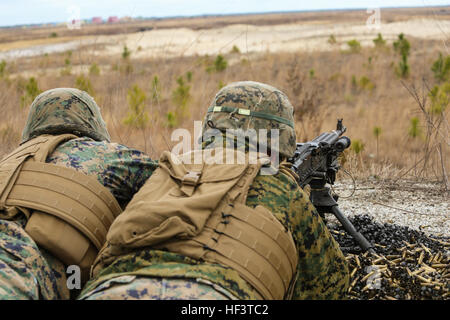 A Marine prepares to fire his M240 machine gun while riding in a ...