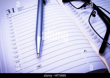 Black book with glasses and pen Stock Photo - Alamy