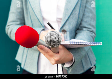 Female reporter taking notes at news conference Stock Photo - Alamy