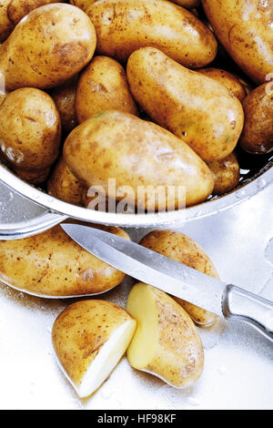 Potatoes in kitchen sieve Stock Photo - Alamy