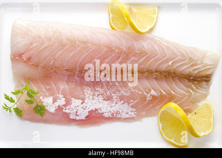 Victoria Sea Bass - raw, fresh fish filets garnished with lemon slices ...