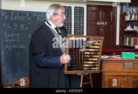 A recreation of a Victorian Classroom. A teacher with an abacus ...