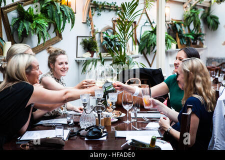 Friends Cheers across a table in a bar restaurant Stock Photo - Alamy