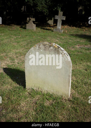 Plain headstone with rounded top with a shadow of leaves on the top ...